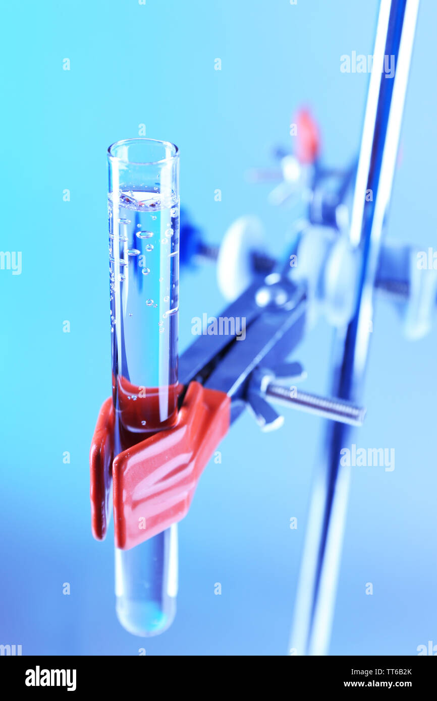Fixed test tube on support on light blue background Stock Photo - Alamy