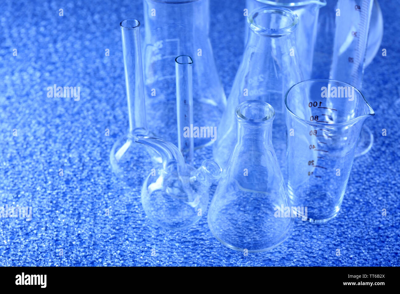 Different laboratory glassware on color background Stock Photo - Alamy