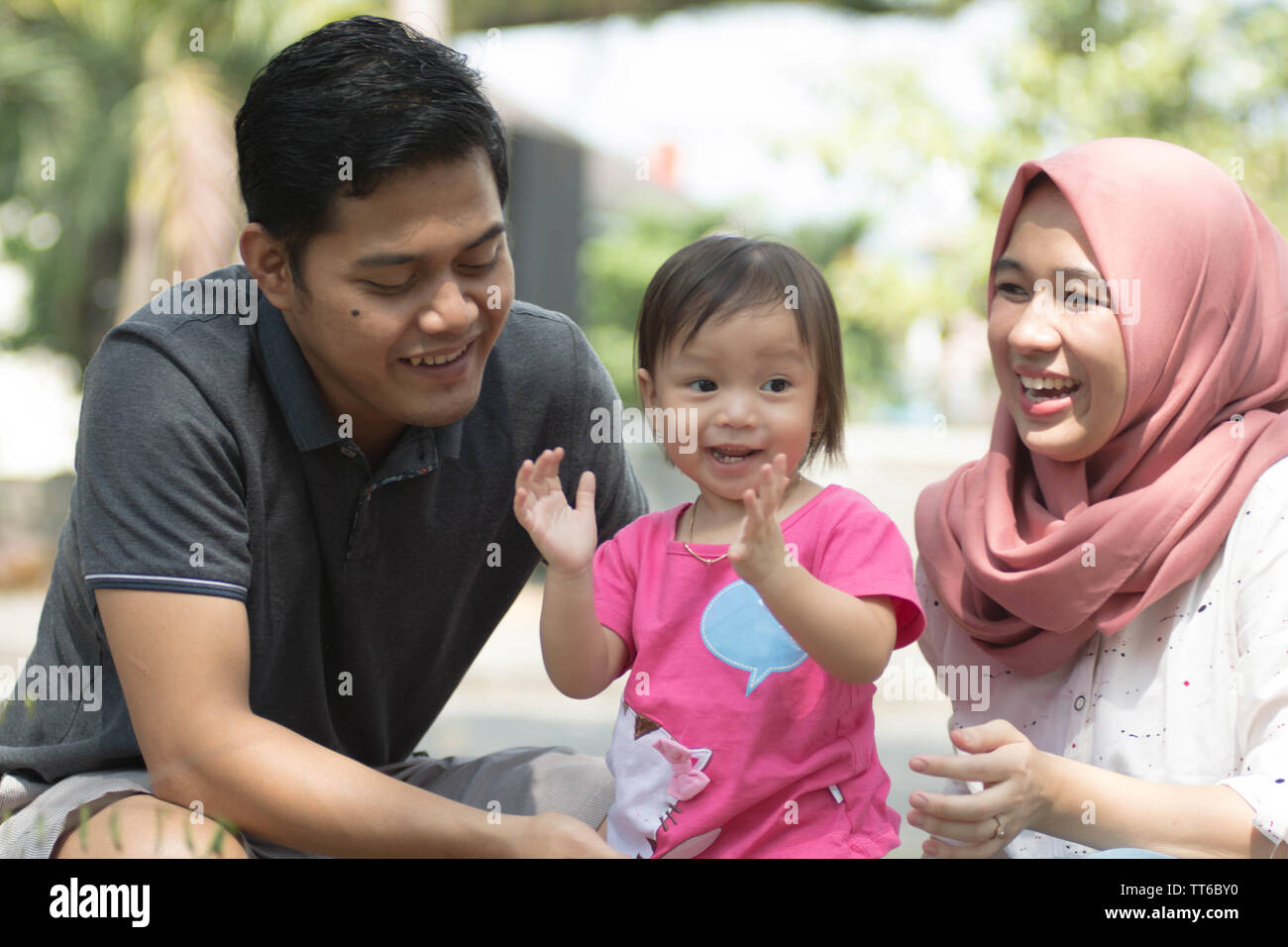 happy young muslim family with one children playing at park laughing in ...