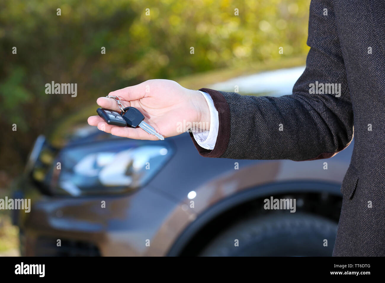 Male hand with car key on car background Stock Photo - Alamy