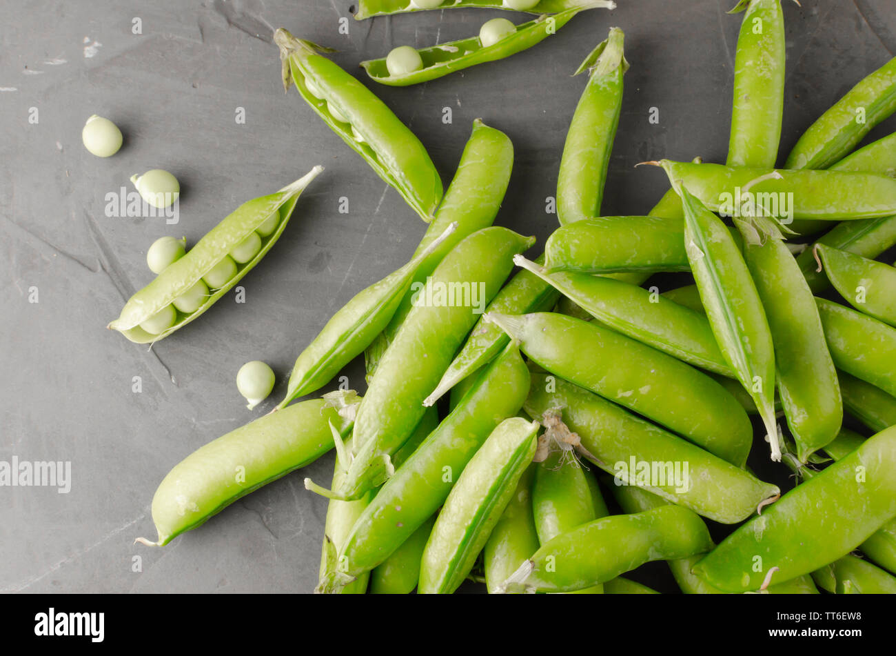 Pods of green peas on the background of concrete Stock Photo - Alamy