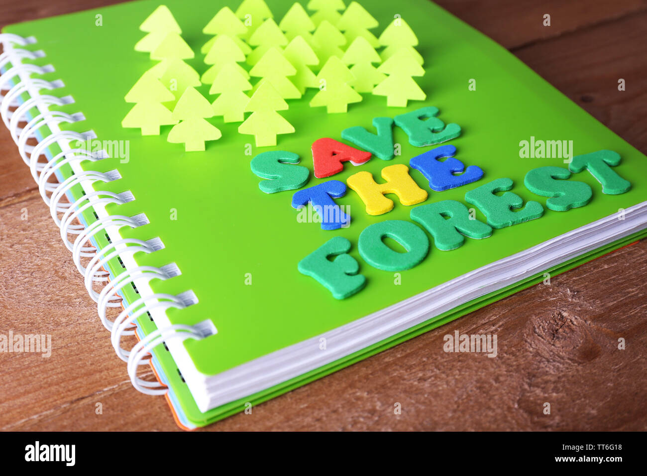 Concept of conservation forests of cut paper on notebook on wooden ...