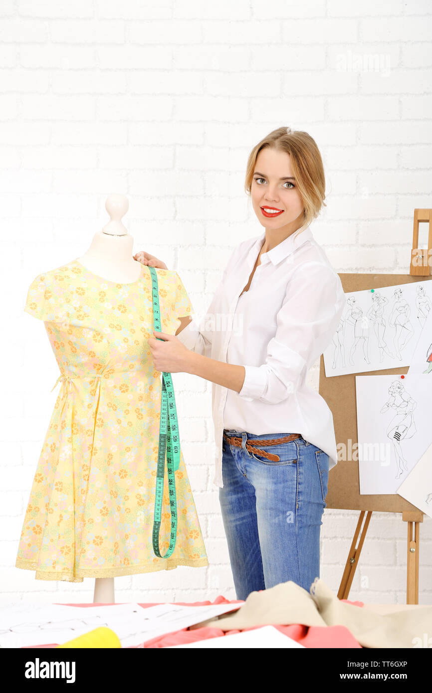 Beautiful young dressmaker in workroom Stock Photo - Alamy