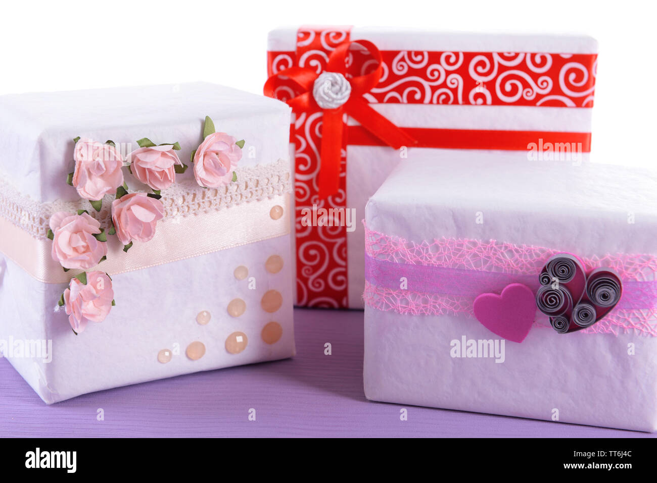 Three cute white present boxes on purple surface isolated on white ...