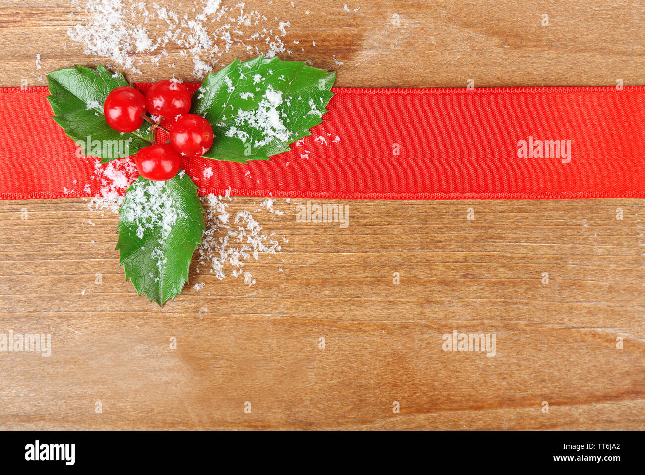 European Holly (Ilex aquifolium) with berries on wooden background ...