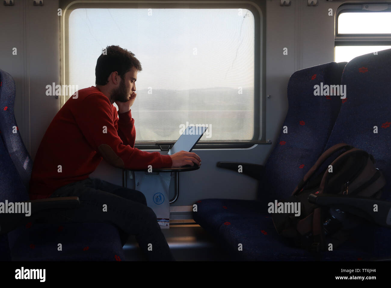A young commuter using a laptop notebook computer in a train. Israel ...
