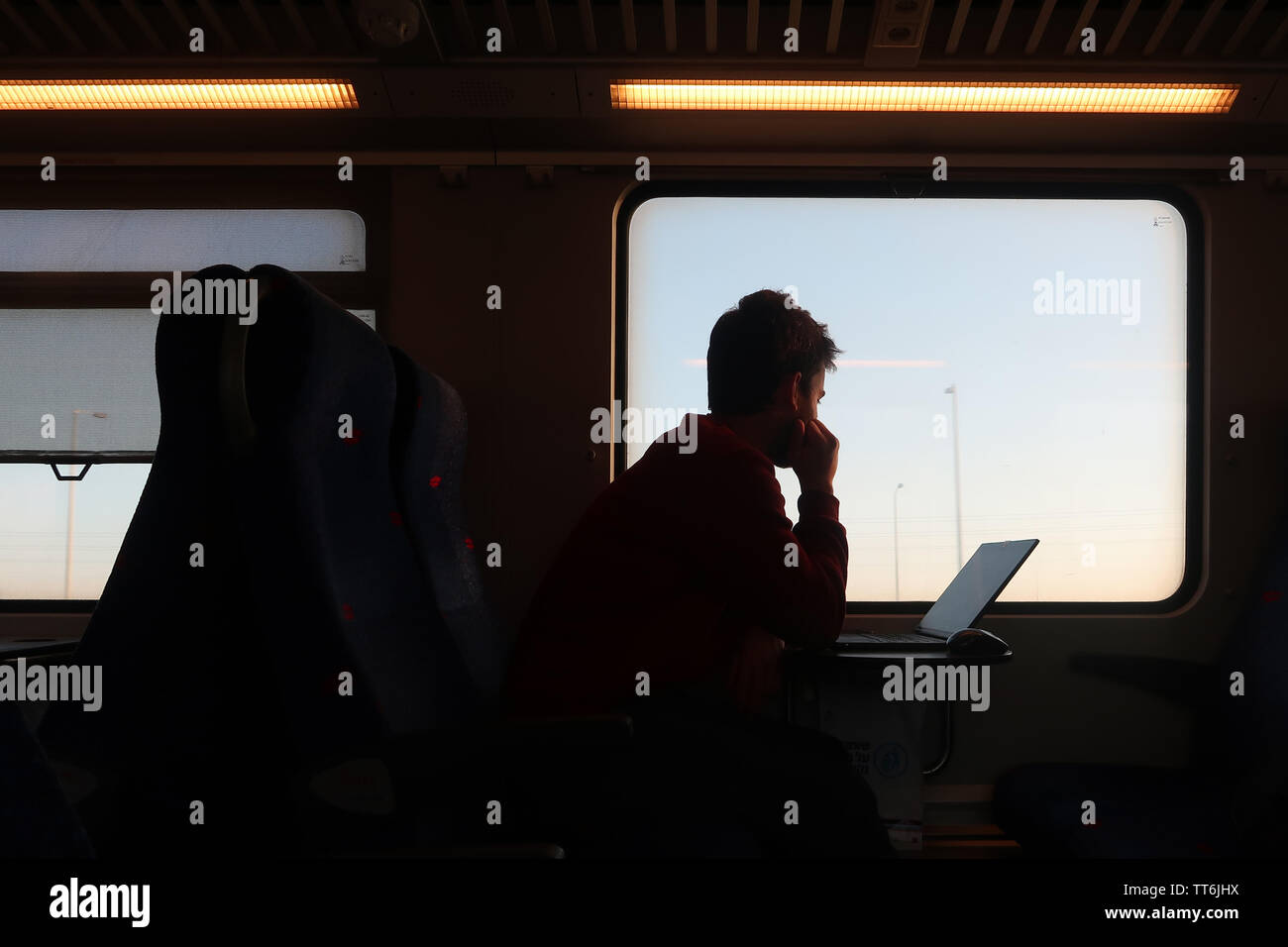 A young commuter using a laptop notebook computer in a train. Israel ...
