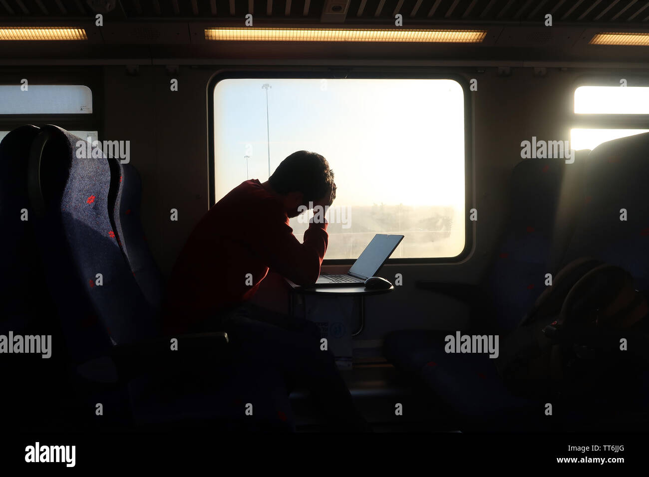 A young commuter using a laptop notebook computer in a train. Israel ...