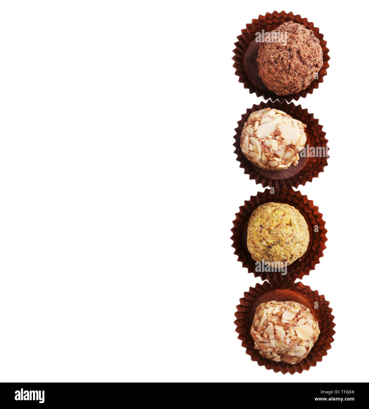 Line of round chocolates in paper bowls isolated on white background ...