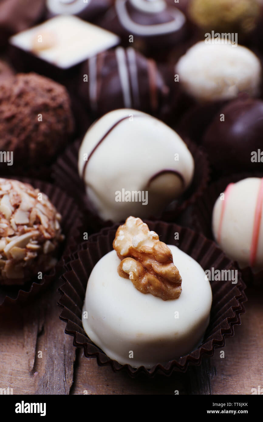 Many chocolates on wooden textured background Stock Photo - Alamy