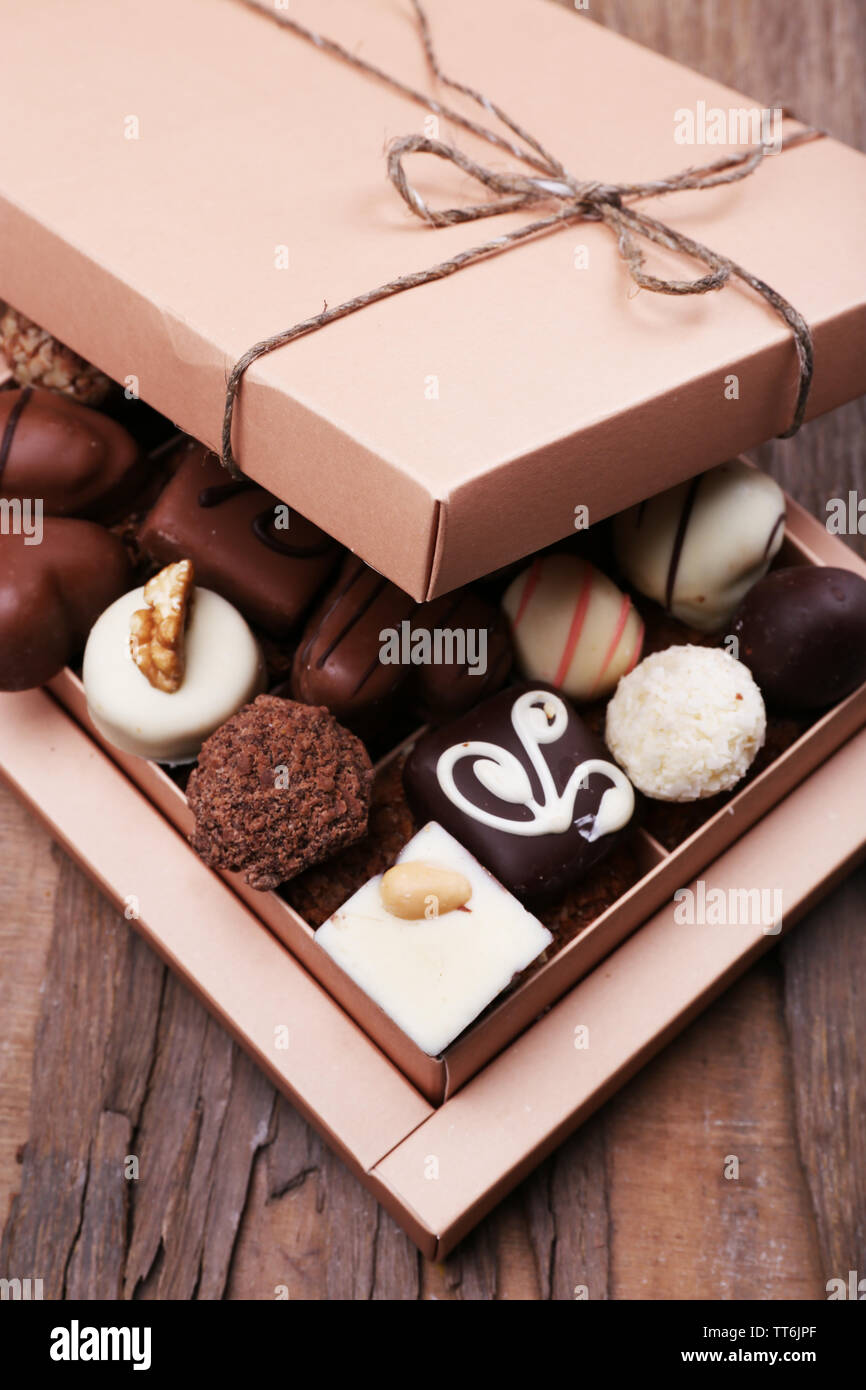Box filled with chocolates on wooden rustic background Stock Photo - Alamy