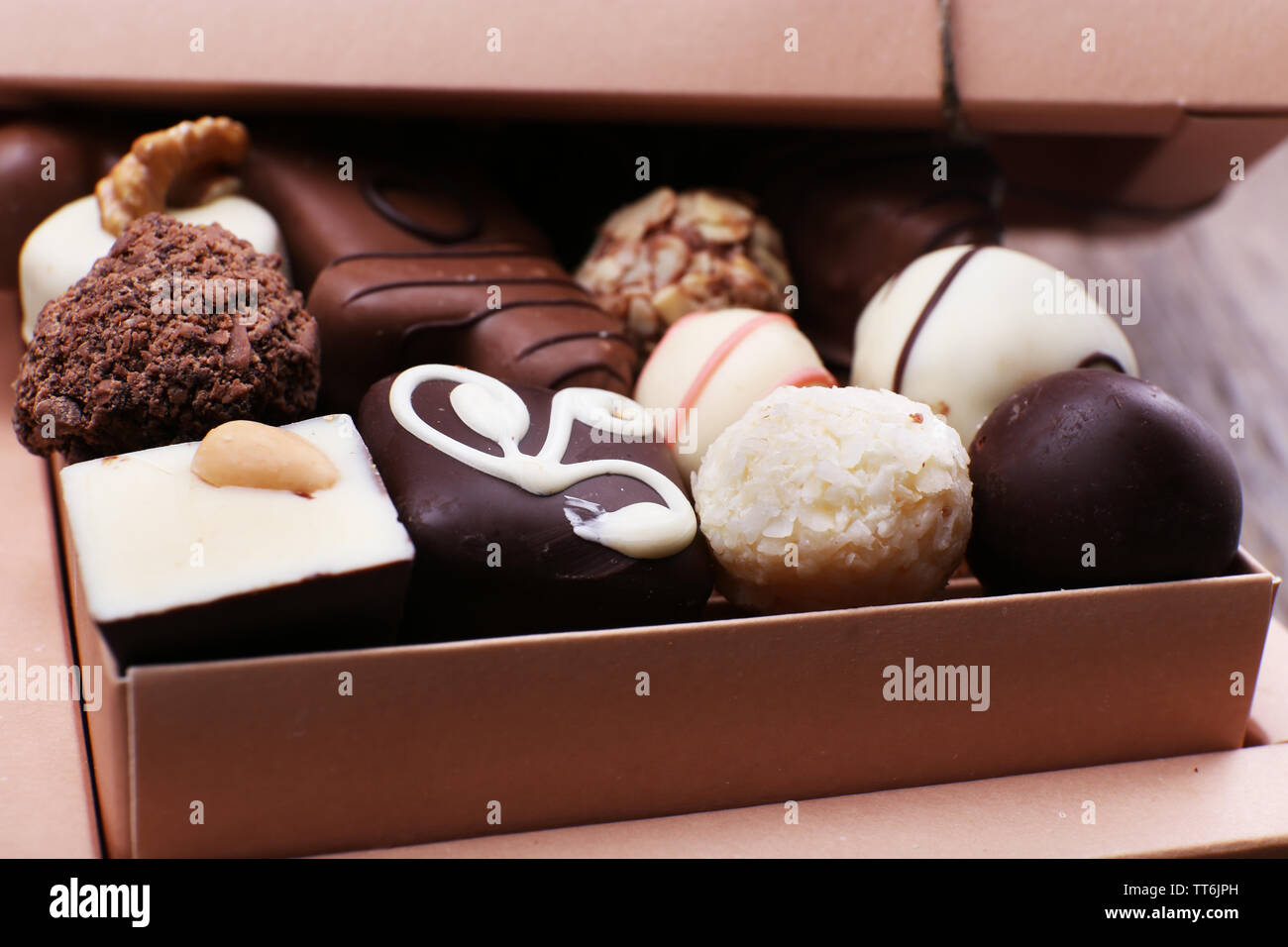 Box filled with chocolates on wooden rustic background Stock Photo - Alamy