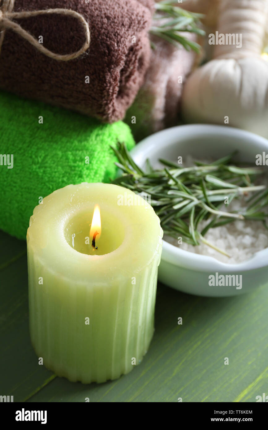 Branches of rosemary and sea salt, towels, candle and bottle with ...