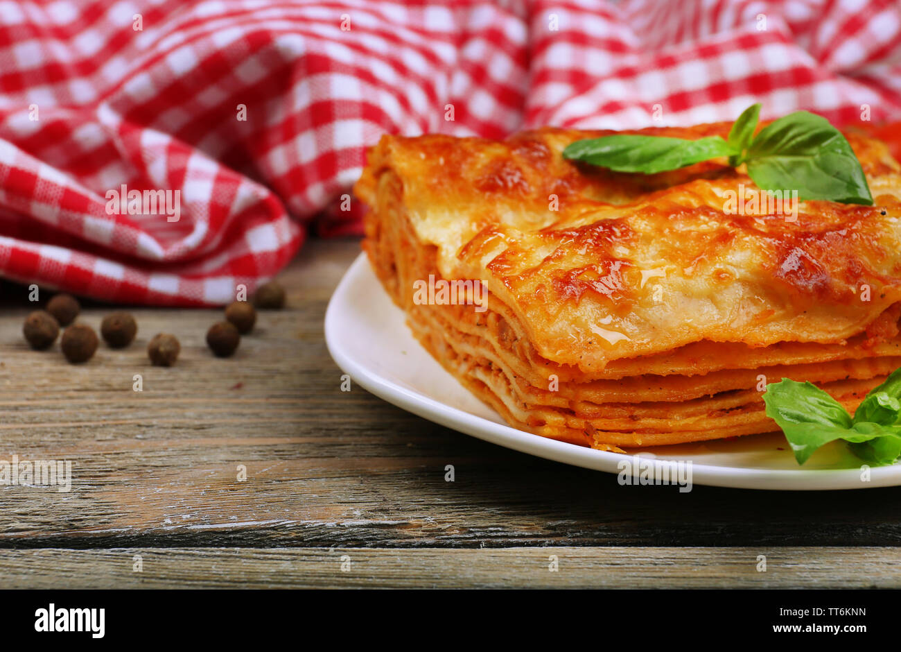 Portion of tasty lasagna on wooden table Stock Photo - Alamy