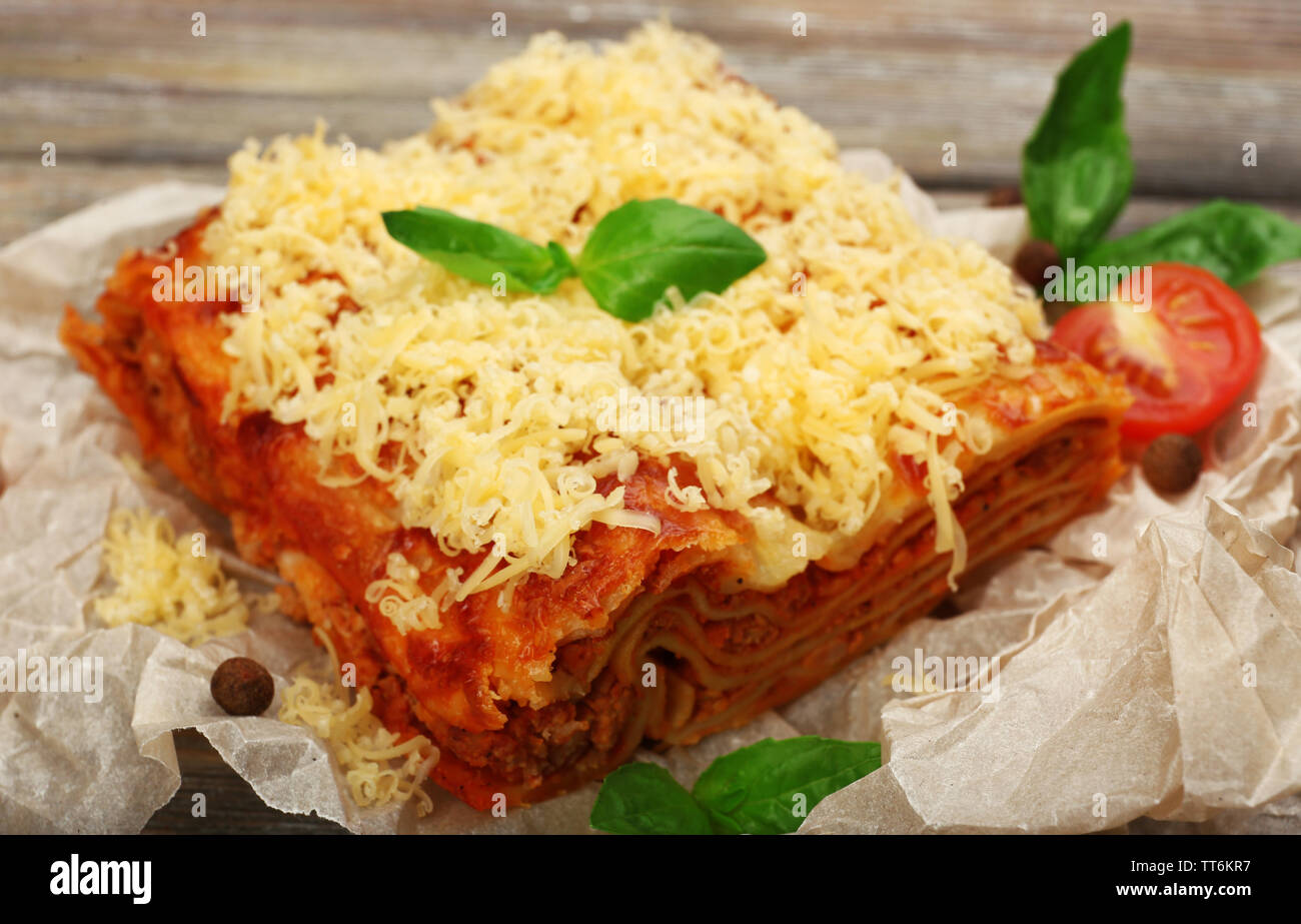 Portion of tasty lasagna on wooden table Stock Photo - Alamy