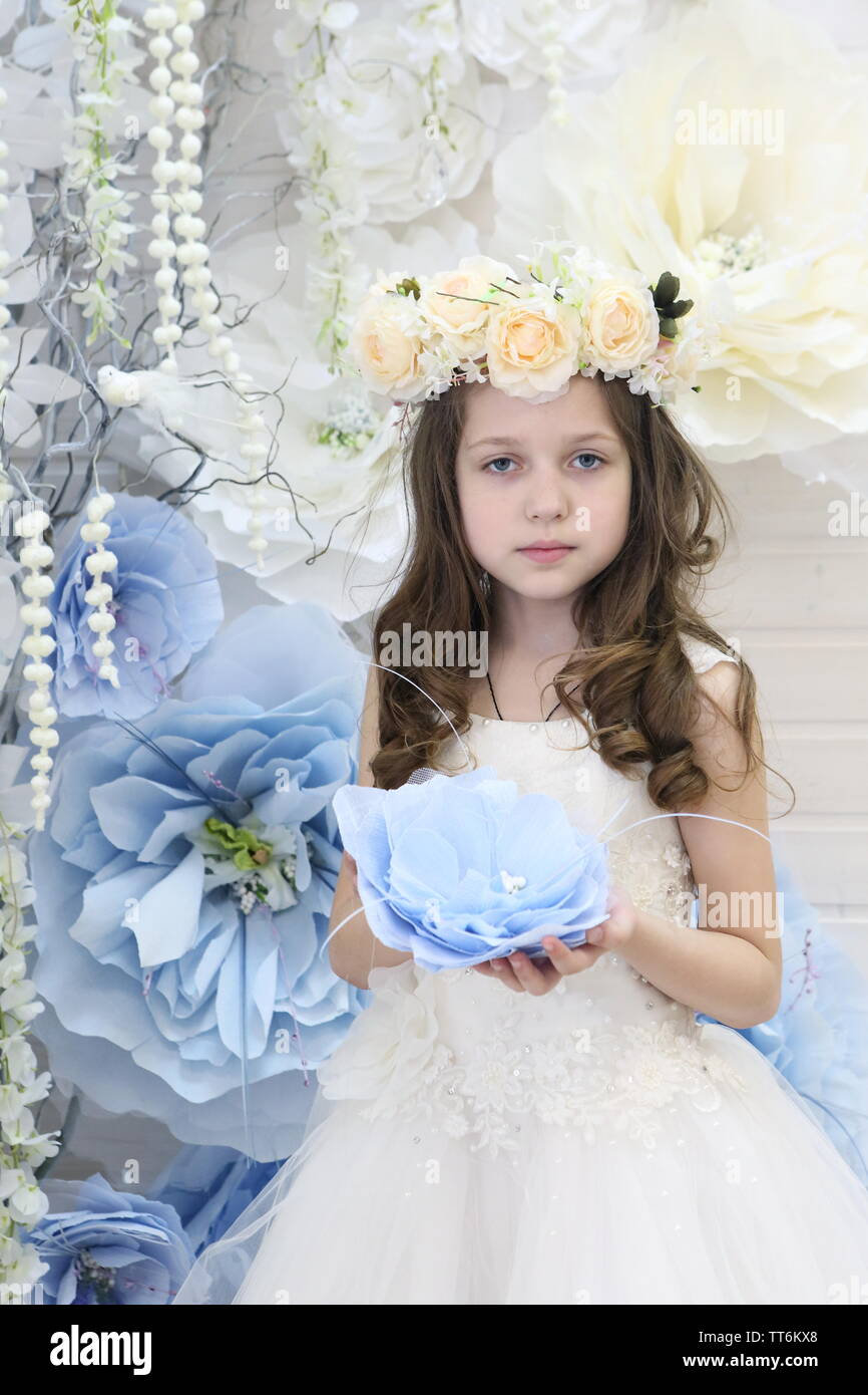 Beautiful girl holding a big blue flower Stock Photo - Alamy