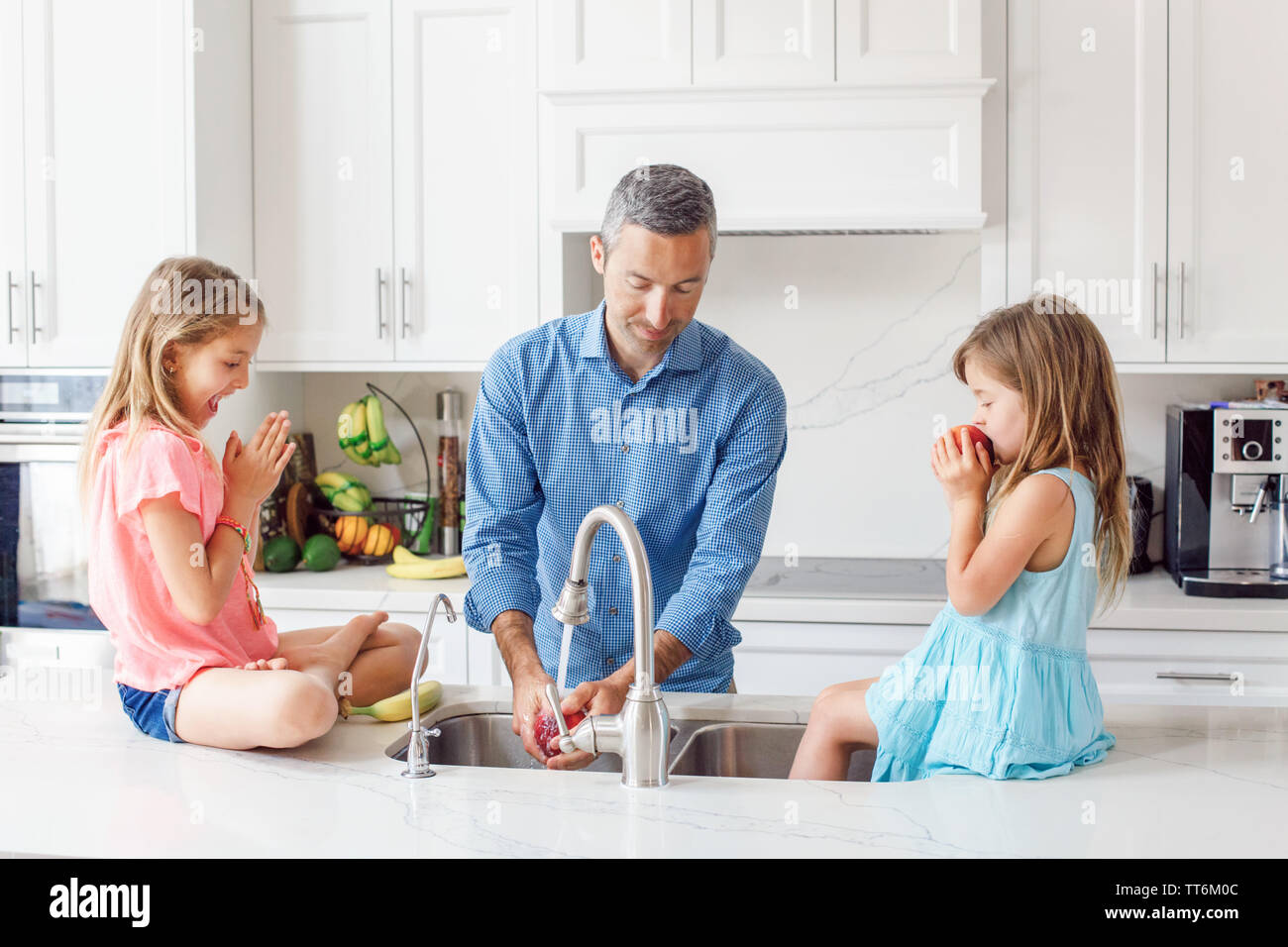 Caucasian father dad gives children daughters fresh fruits to eat ...
