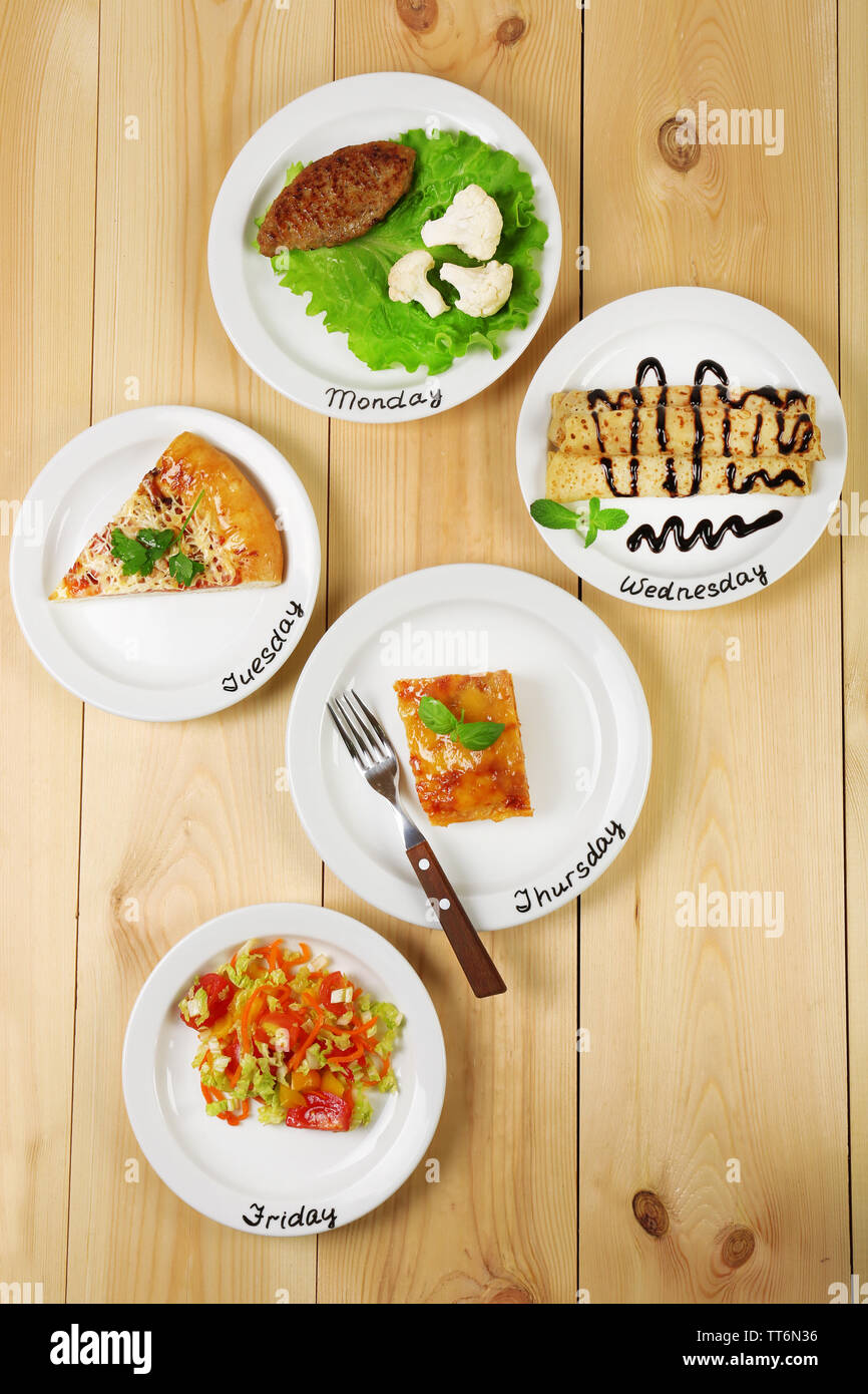 Daily menu. Plates with food on table Stock Photo - Alamy