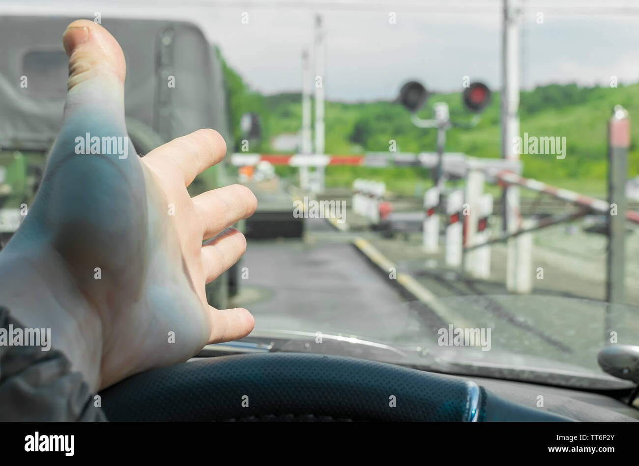 The hand of man inside the car. The car stopped in front of a closed ...