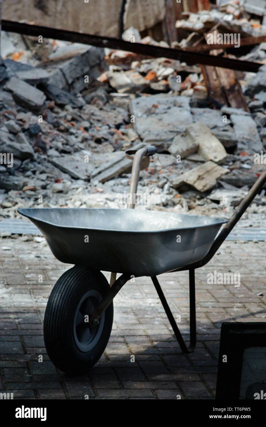 wheelbarrow on the background of demolition of a garage - construction ...