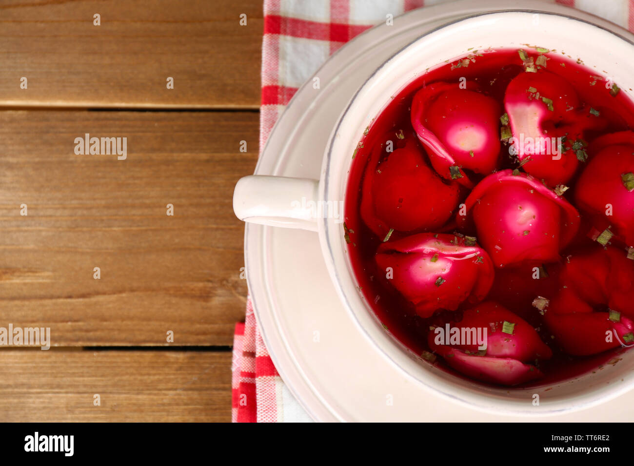 Traditional polish clear red borscht with dumplings on wooden ...