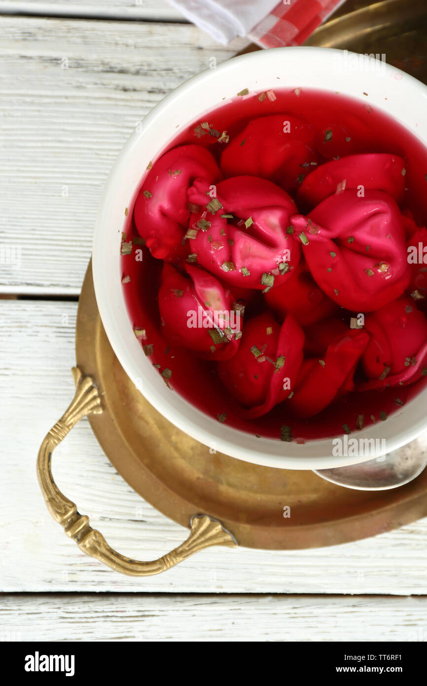 Traditional polish clear red borscht with dumplings on wooden ...