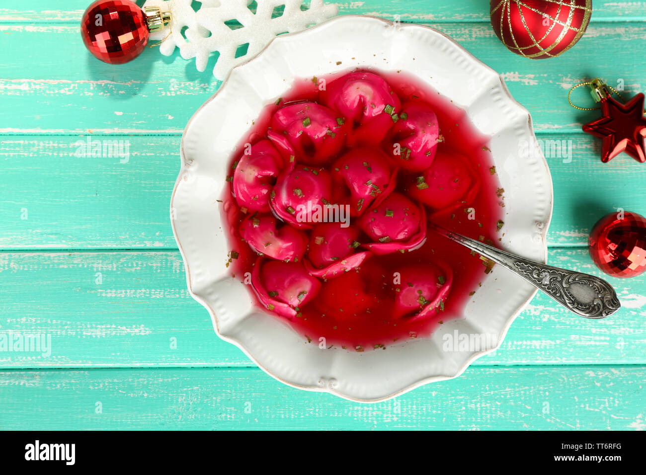Traditional polish clear red borscht with dumplings on color wooden ...