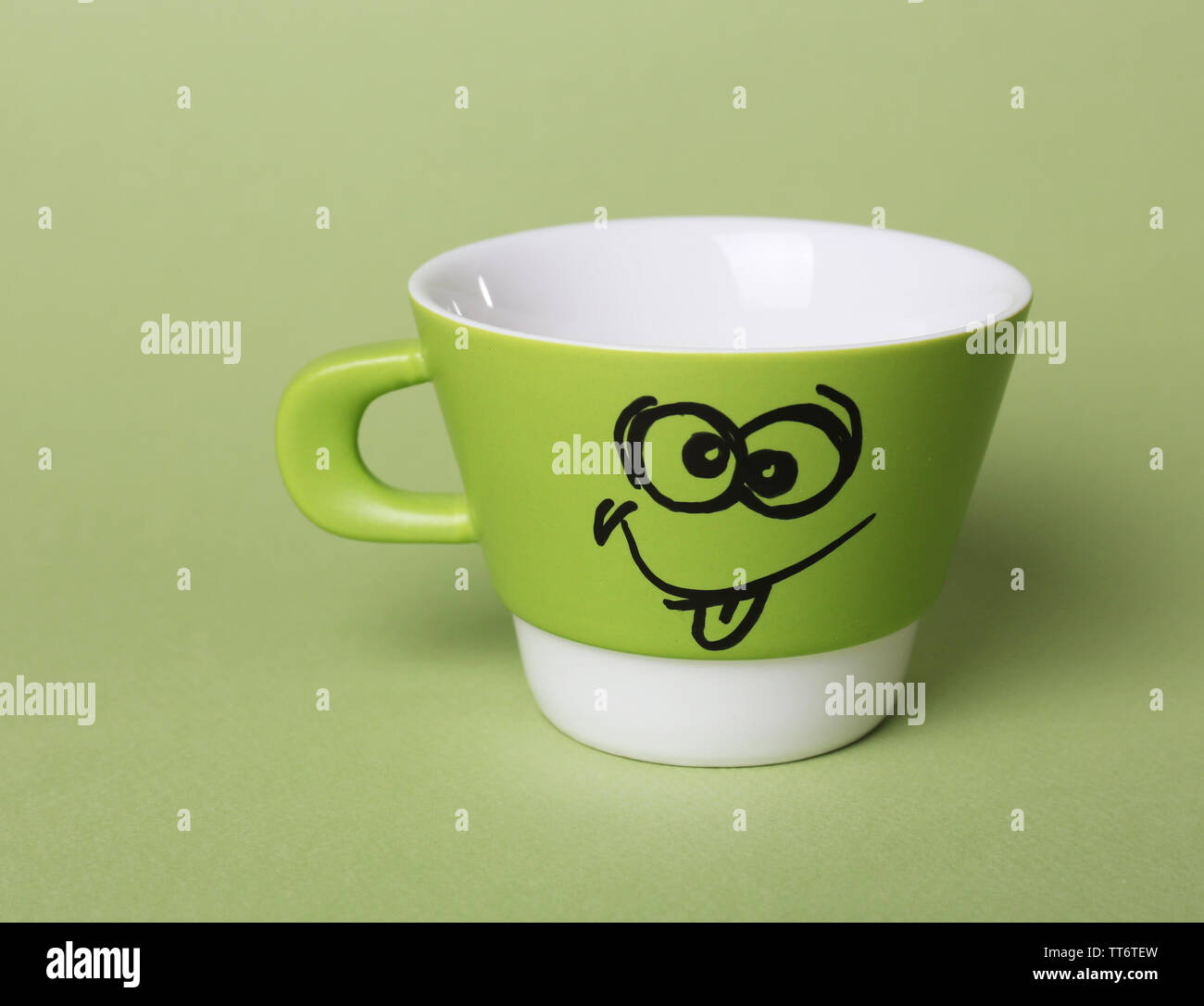 Emotional cup on green background Stock Photo - Alamy