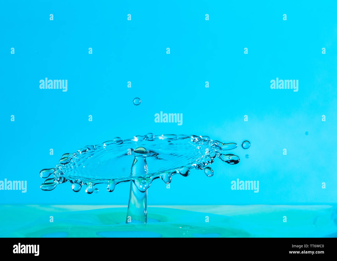 water drop falling and impacting a body of water after hitting the ...