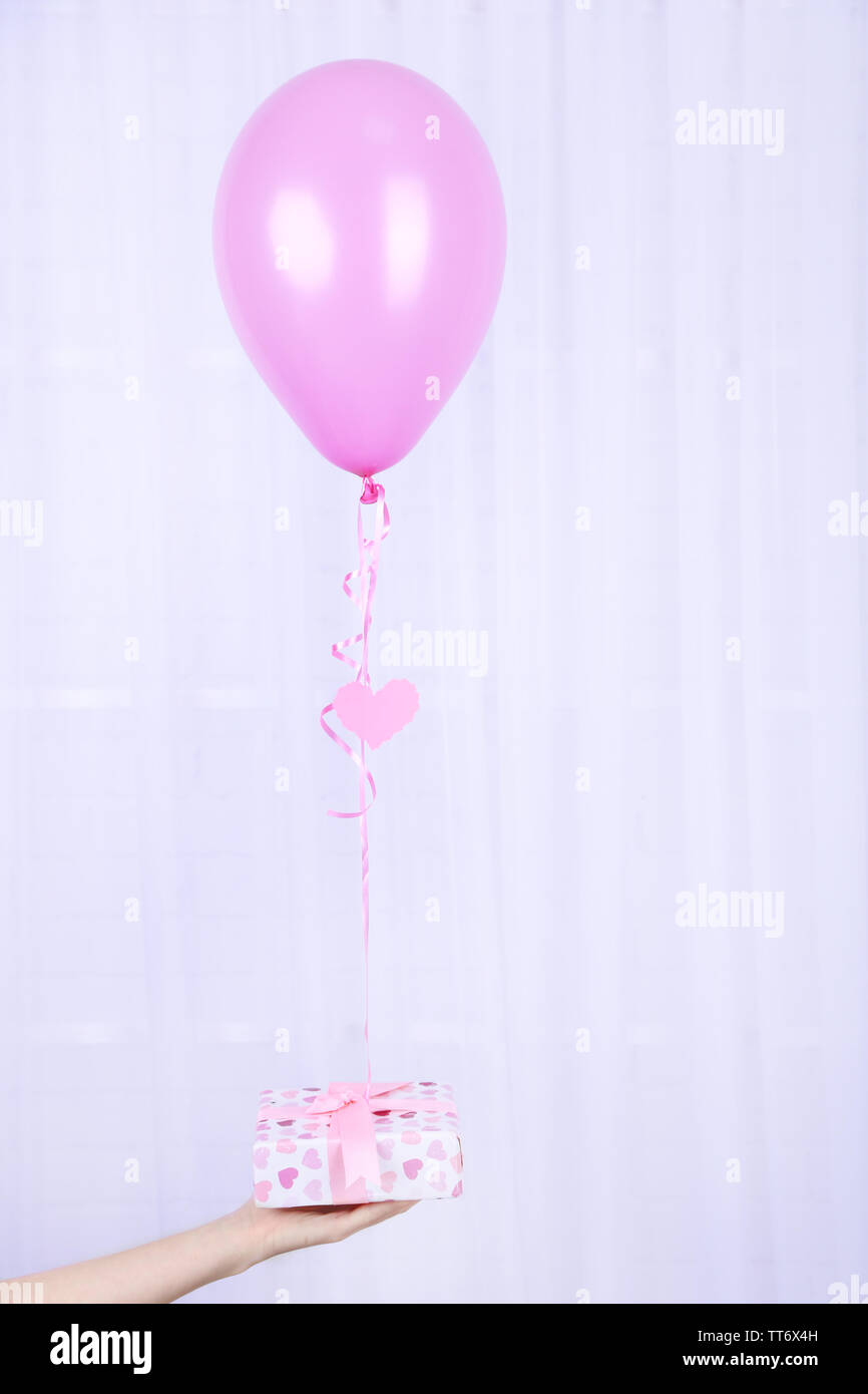 Hand holding balloon with gift Stock Photo - Alamy