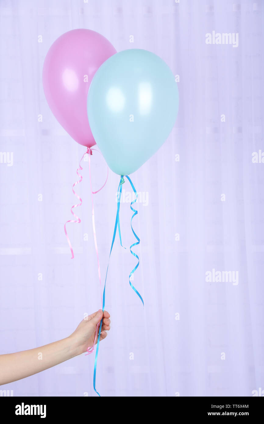 Hand holding blue and pink balloons Stock Photo - Alamy
