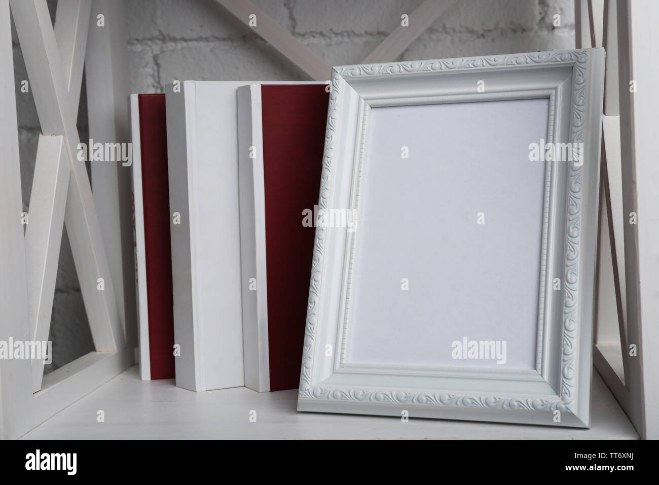 Photo frame with books on shelf, on brick wall background Stock Photo ...