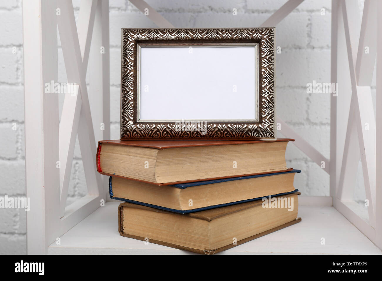 Photo frame with books on shelf, on Stock Photo - Alamy