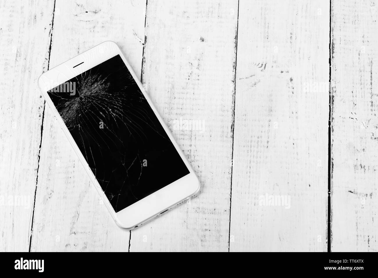 Broken iPhone on wooden background Stock Photo - Alamy