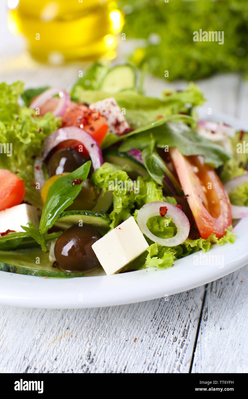 Greek salad in plate on color wooden table background Stock Photo - Alamy