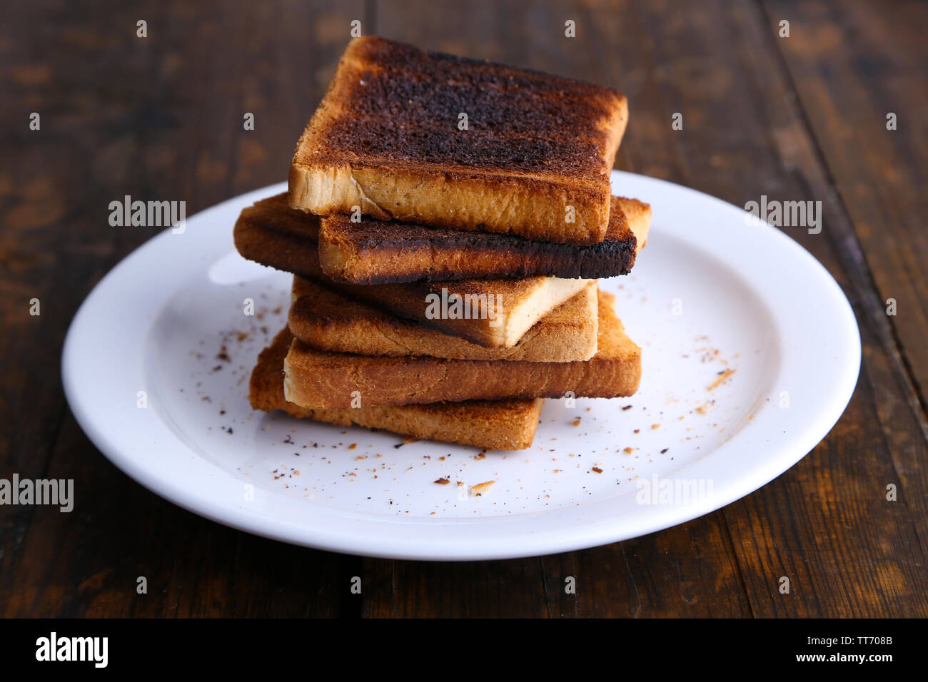Burnt toast bread on plate, on wooden table background Stock Photo - Alamy