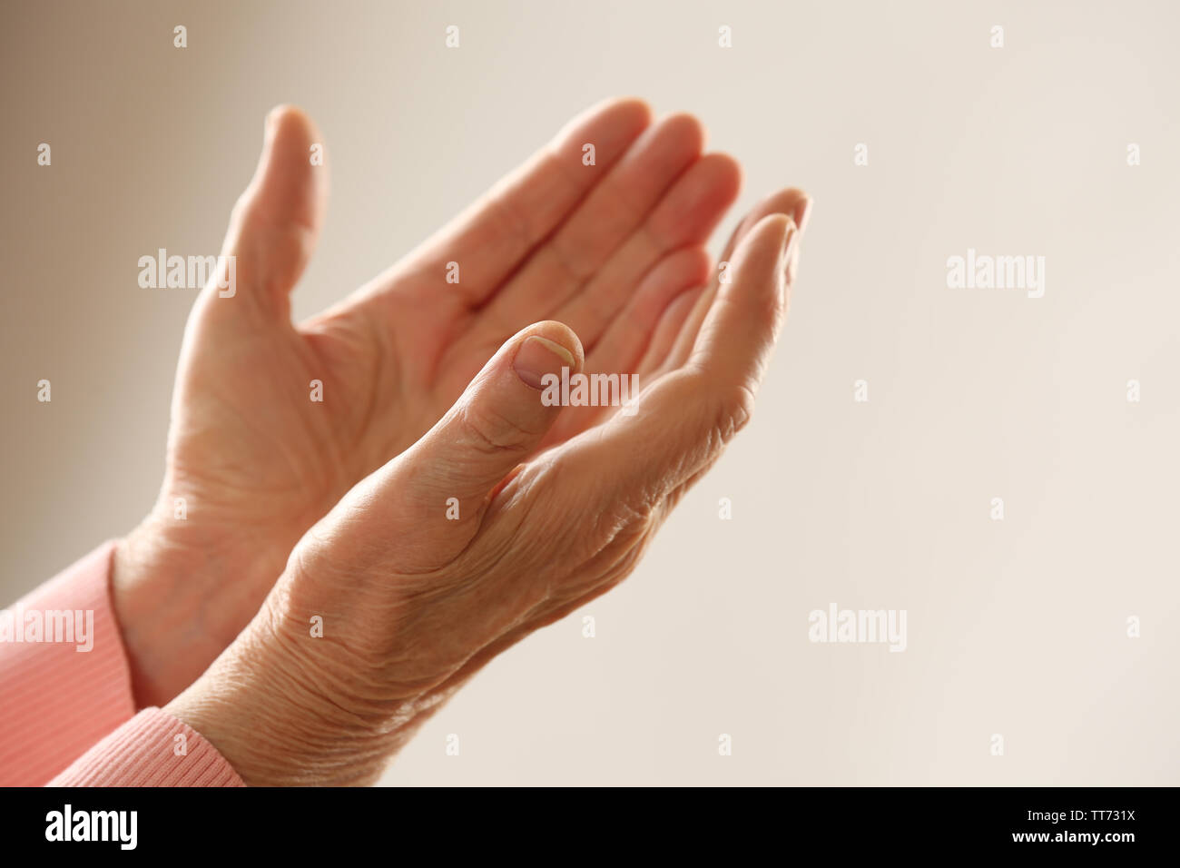 Hands of old woman on light background Stock Photo - Alamy
