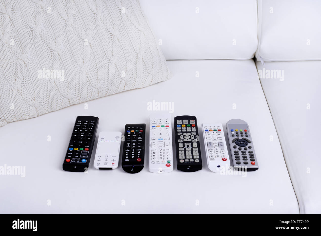 Many remote control devices on sofa Stock Photo - Alamy