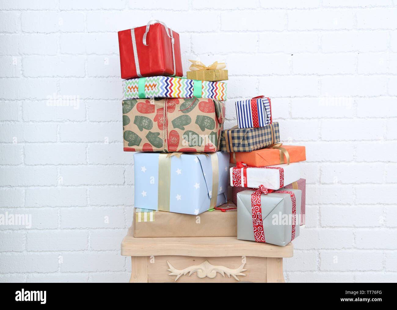Pile of present boxes on stool on brick wall background Stock Photo - Alamy