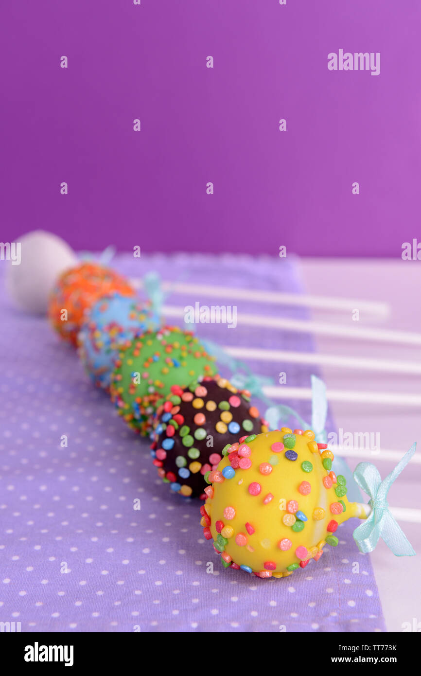 Sweet cake pops on table on purple background Stock Photo - Alamy