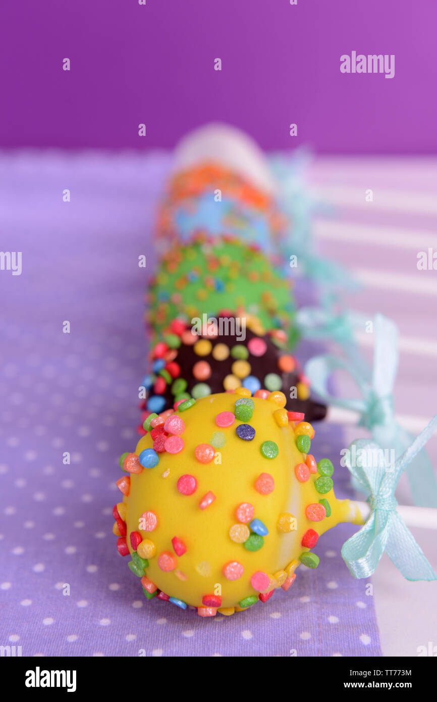 Sweet cake pops on table on purple background Stock Photo - Alamy
