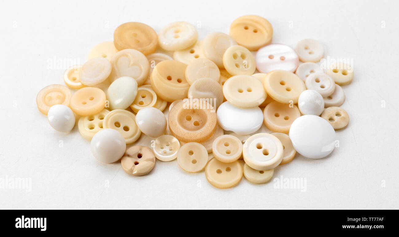 Beige sewing buttons isolated on white Stock Photo - Alamy