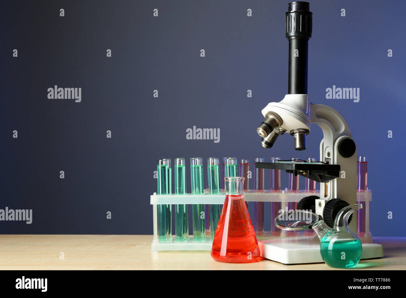 Microscope and test tubes on table, on color background Stock Photo - Alamy