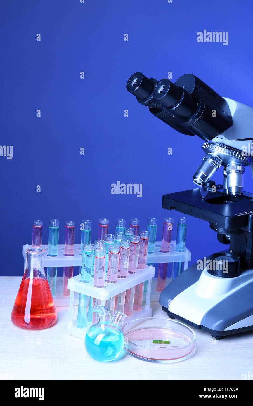 Microscope and test tubes on table, on color background Stock Photo - Alamy