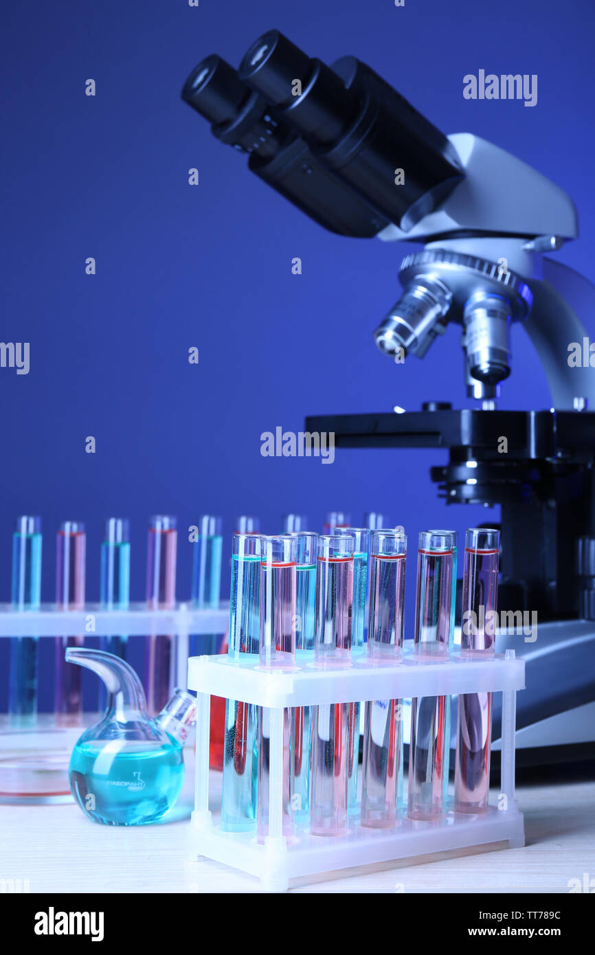 Microscope and test tubes on table, on color background Stock Photo - Alamy