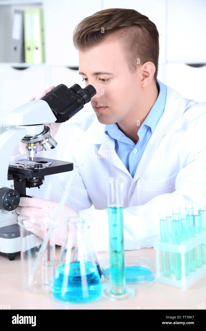 Male scientist using microscope in laboratory Stock Photo - Alamy