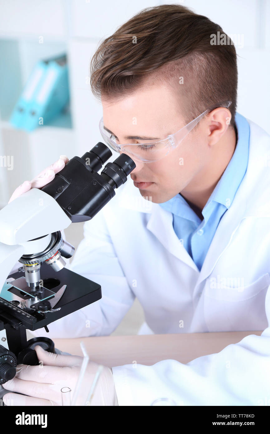 Male scientist using microscope in laboratory Stock Photo - Alamy