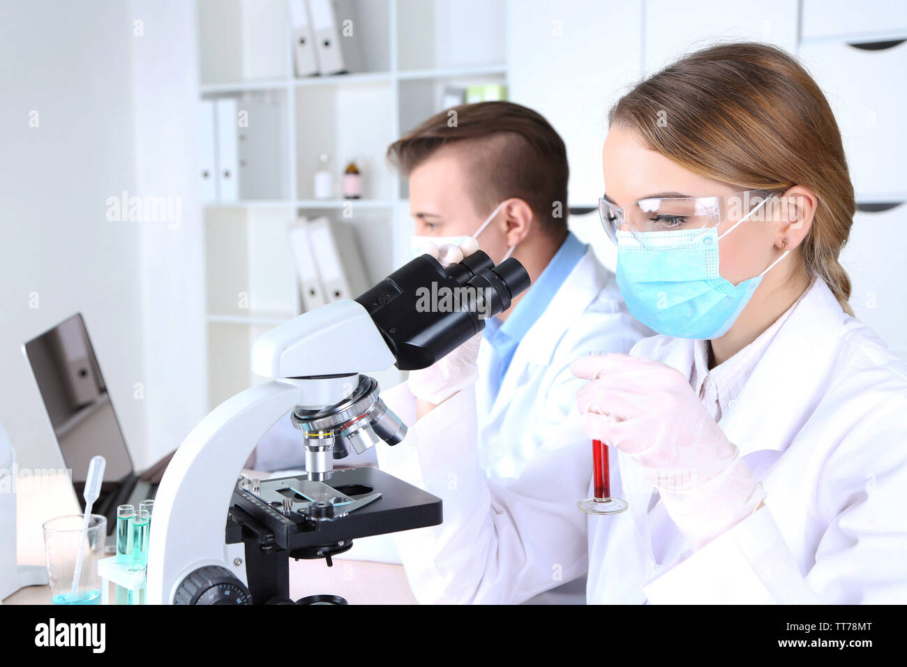 Young female and male scientists with microscope in laboratory Stock ...