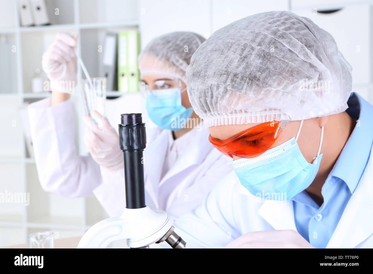Male and female scientists using microscope in laboratory Stock Photo ...