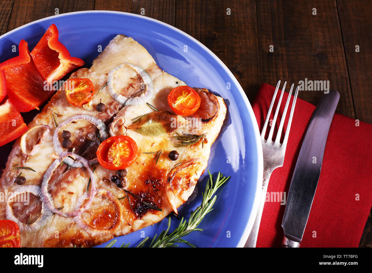 Dish of Pangasius fillet with spices and vegetables on wooden table ...